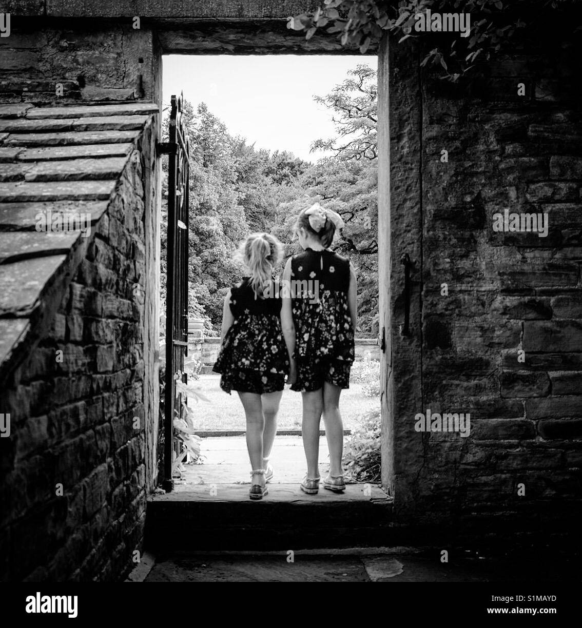 Two girls stood in a gateway Stock Photo - Alamy