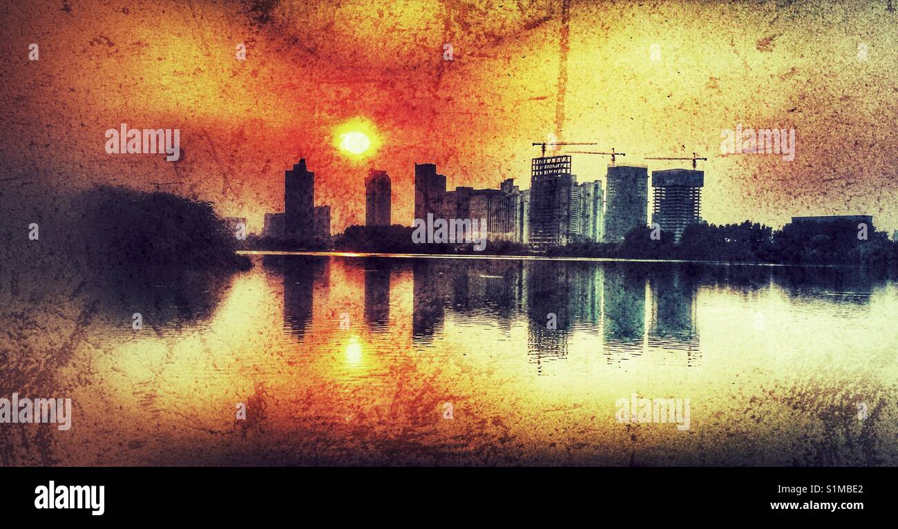 Grunge style image of a sunset behind a city skyline Stock Photo - Alamy