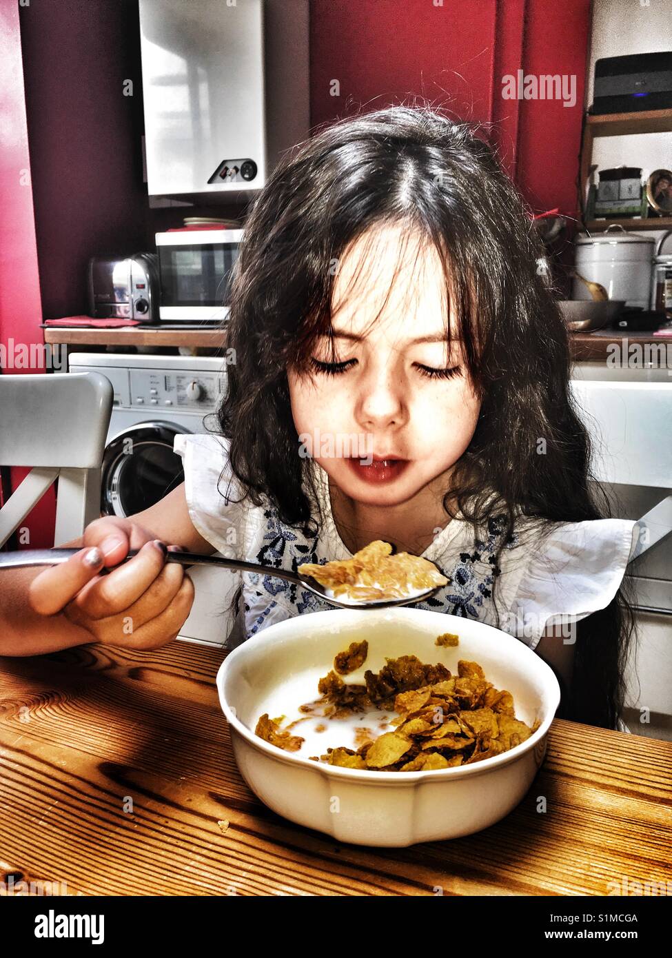 Girl eating breakfast Stock Photo - Alamy