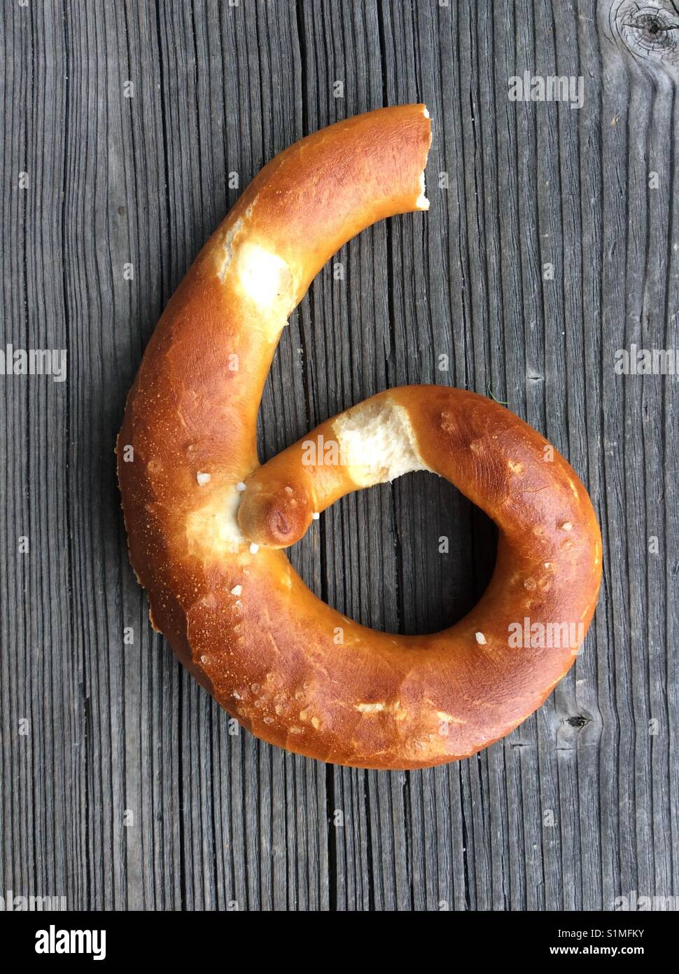 Bavarian Pretzel shaped like number 6 on weathered board Stock Photo ...