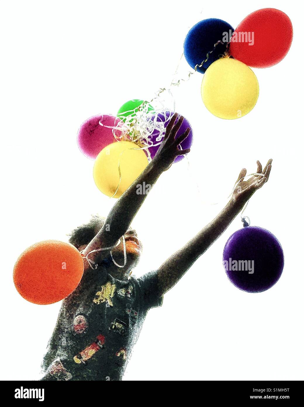 A little boy catches colourful balloons Stock Photo - Alamy