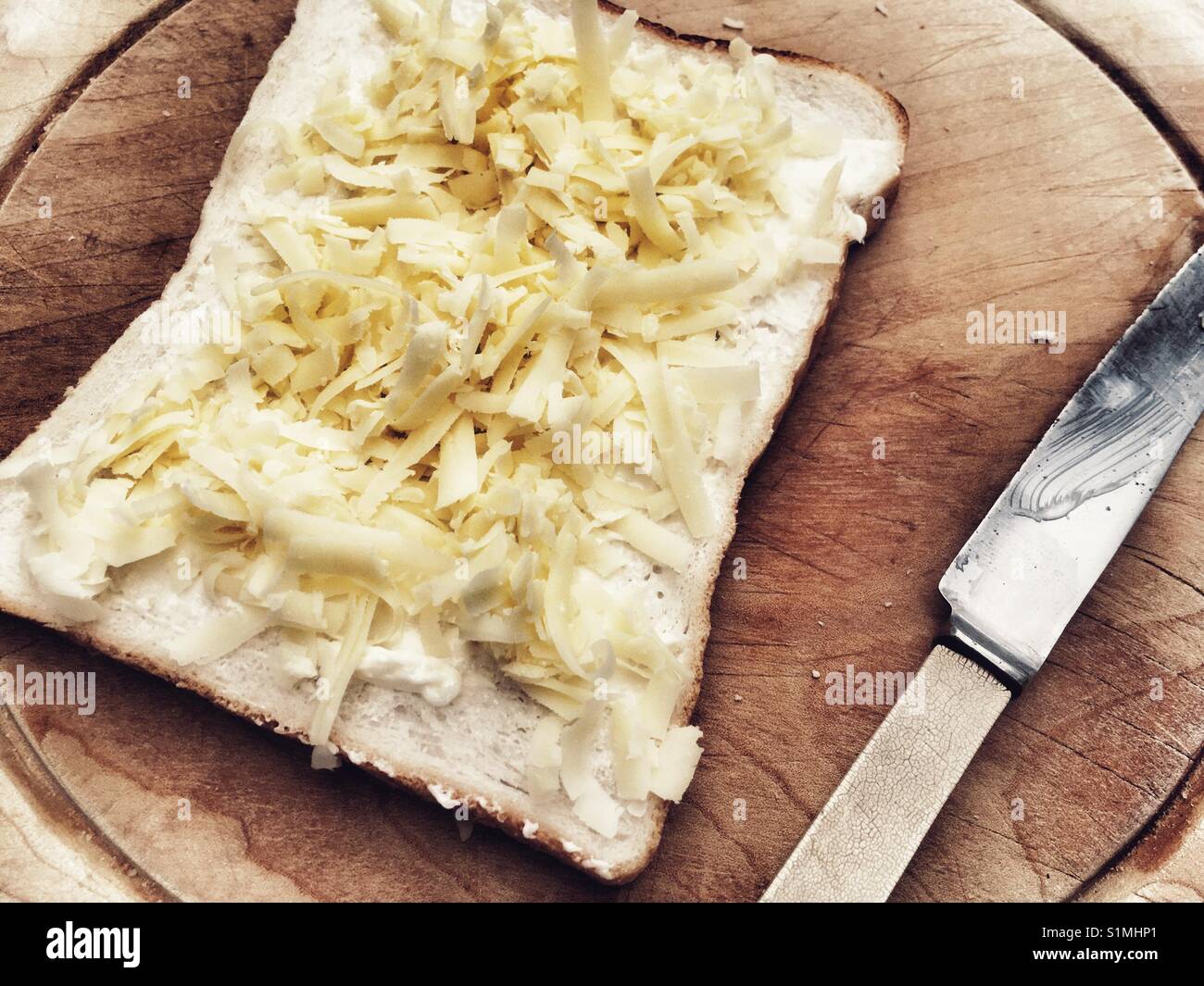 Grated cheddar cheese on sliced bread Stock Photo - Alamy