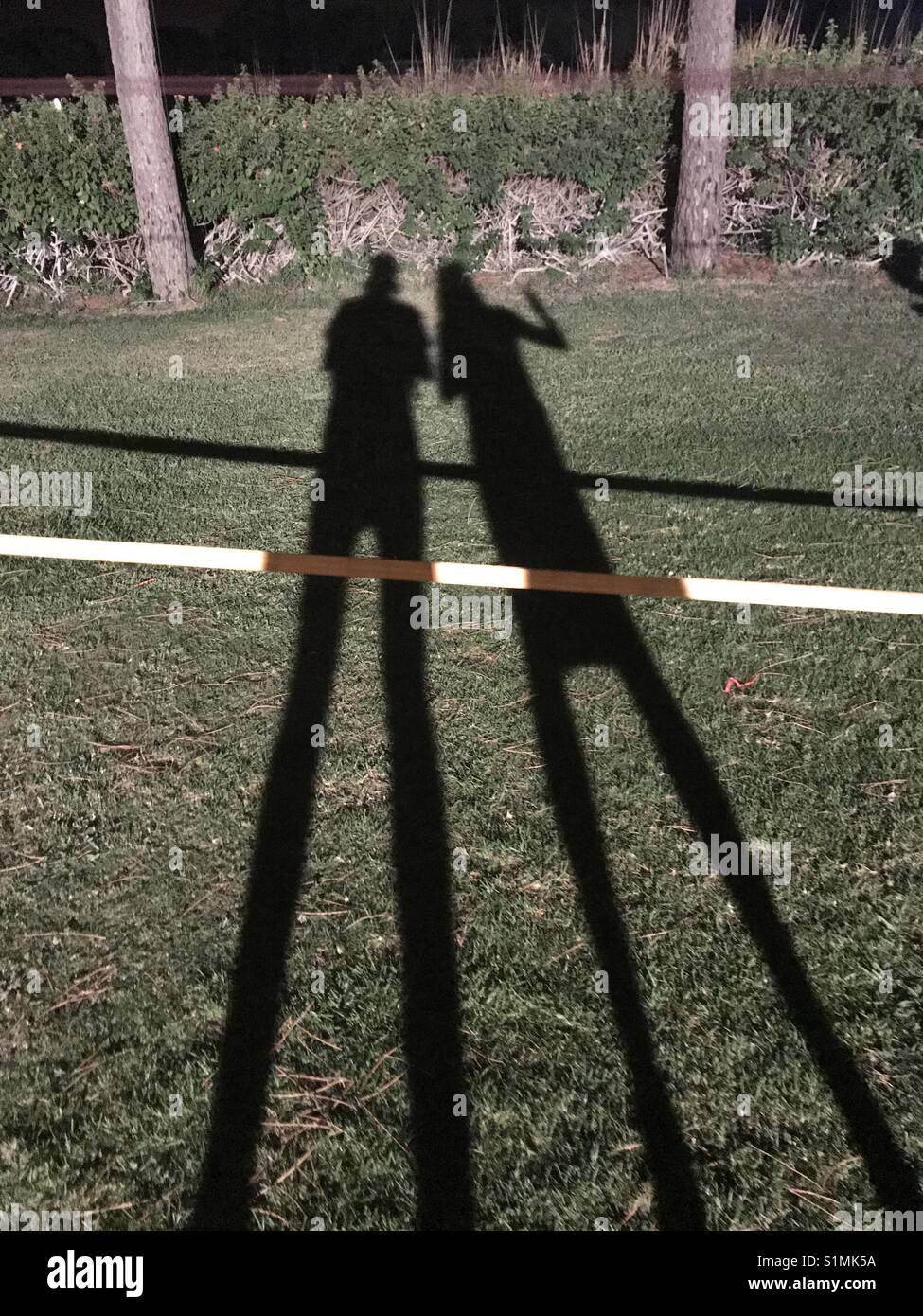 Long shadows of people at night Stock Photo - Alamy