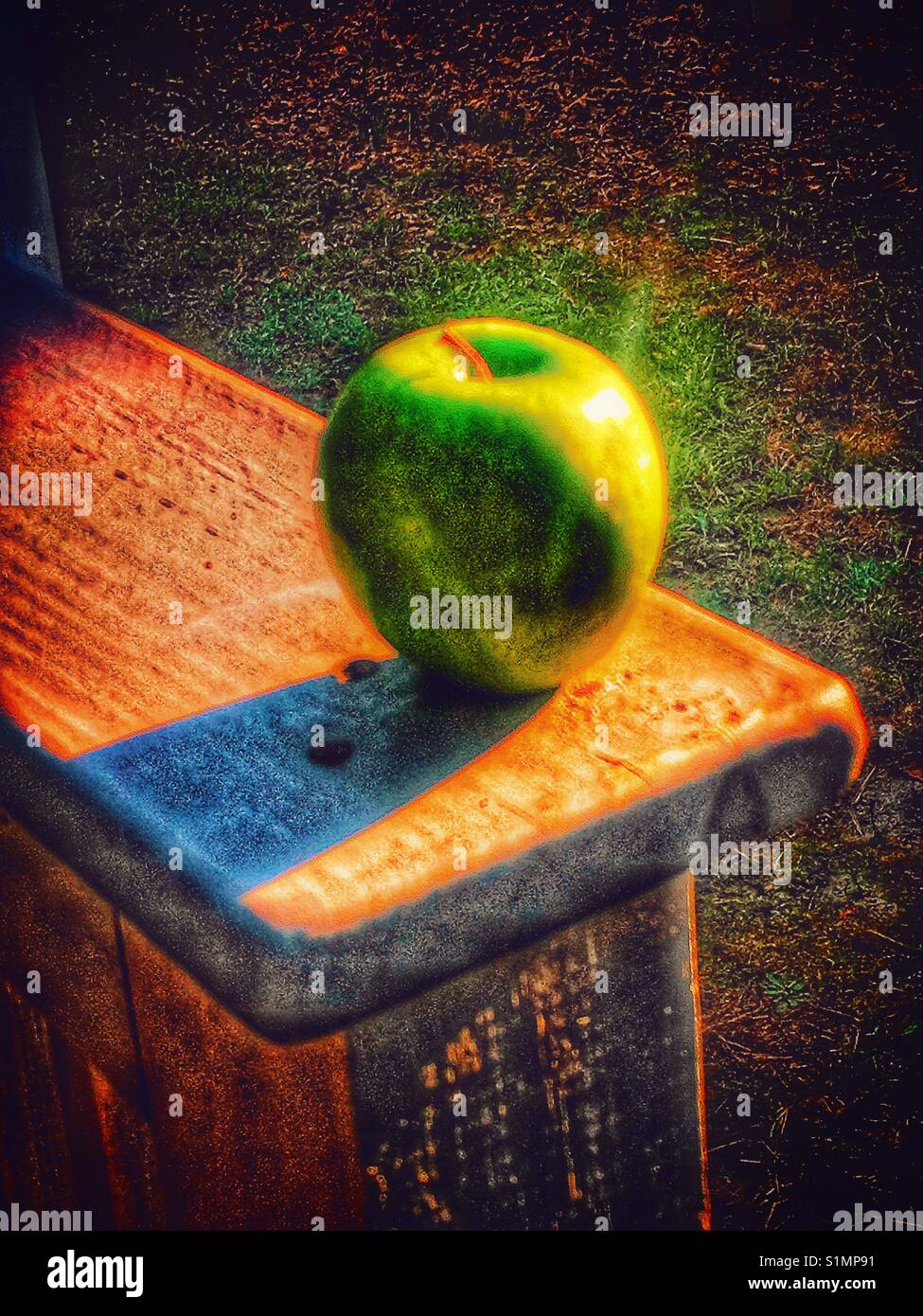 A green shiny apple casts a shadow; end of summer Stock Photo - Alamy