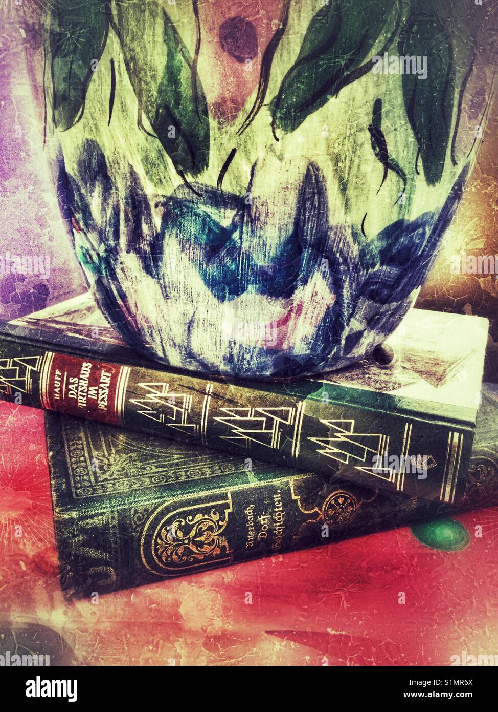 Hand painted vase standing on two old books Stock Photo - Alamy
