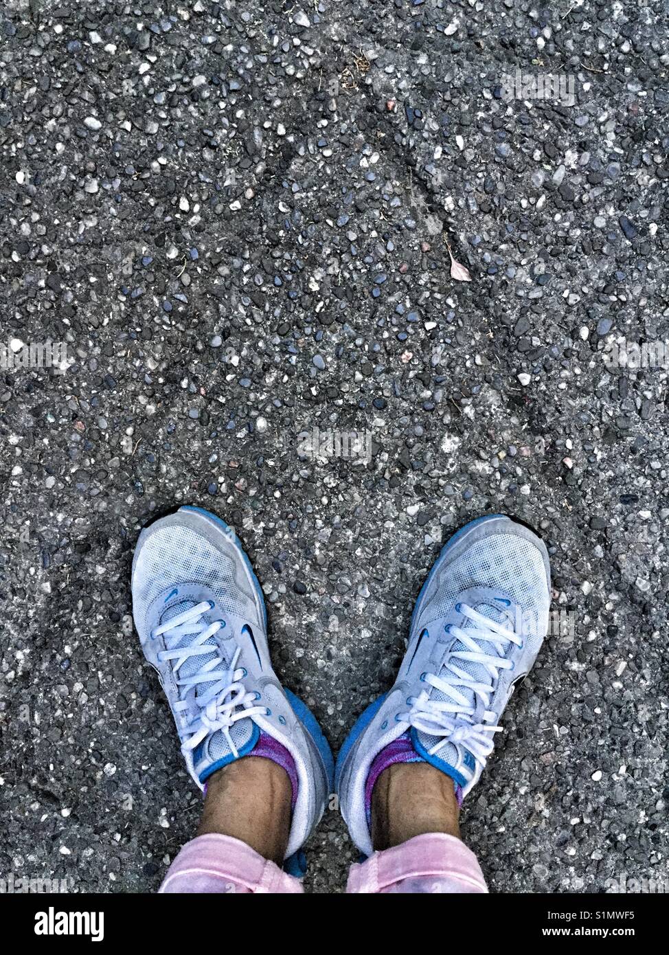Feet form a V within an upside down V etched in a concrete walkway ...