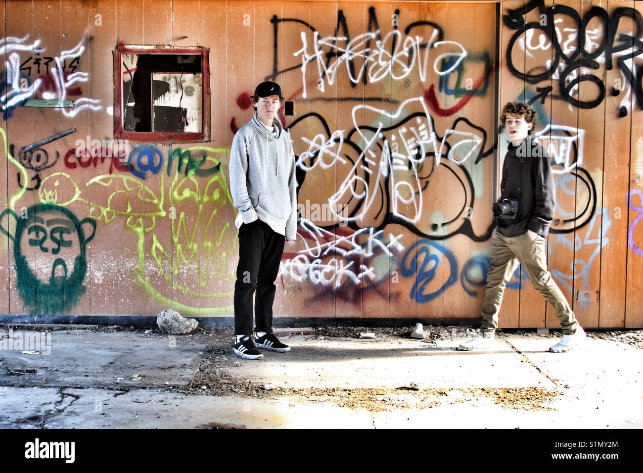 Teen boys with a graffiti wall in the background Stock Photo - Alamy