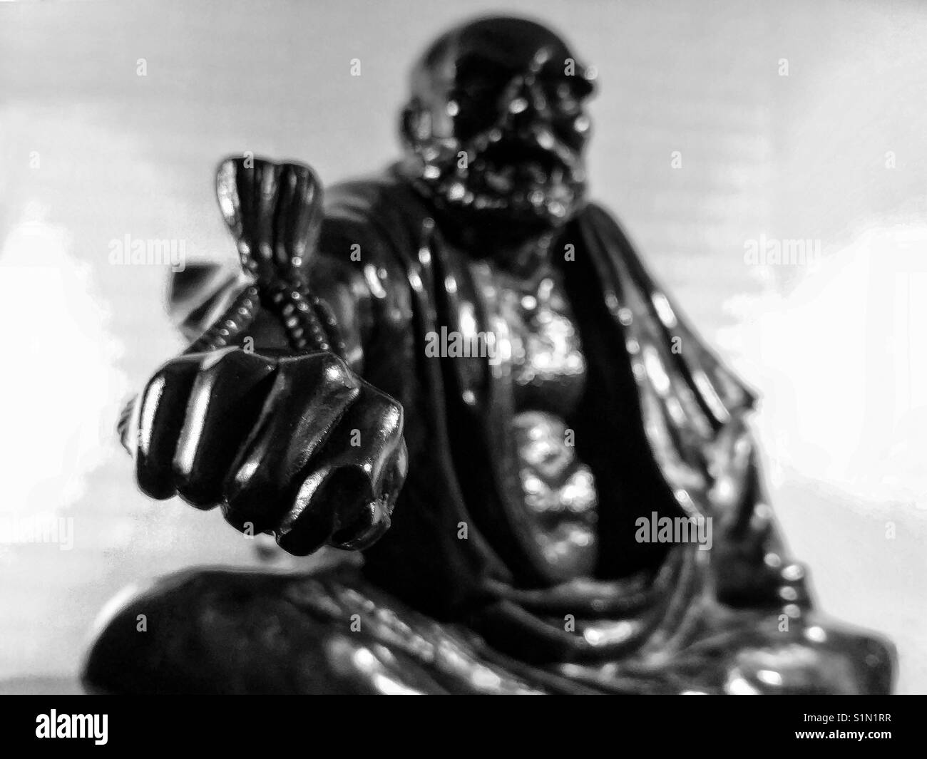 Close-up of a sculpture of a sitting stern, strict japanese buddhist ...
