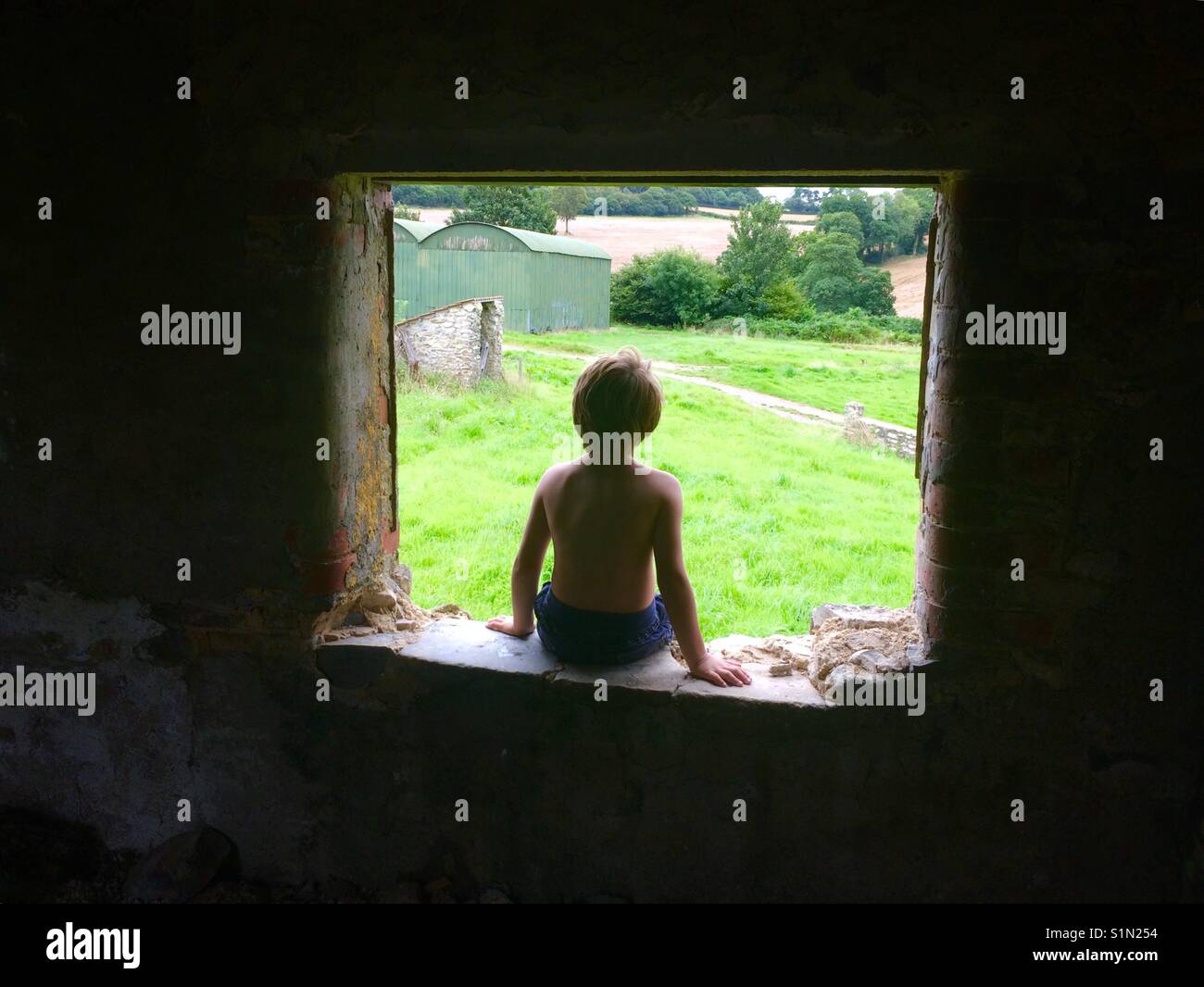 Boy in window frame Stock Photo - Alamy
