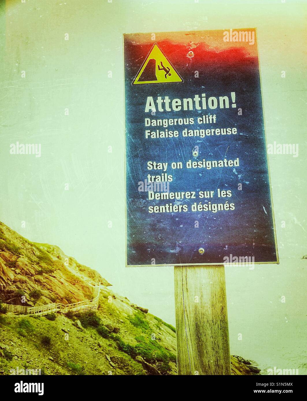 Dangerous cliff sign in English and French, Canada Stock Photo - Alamy