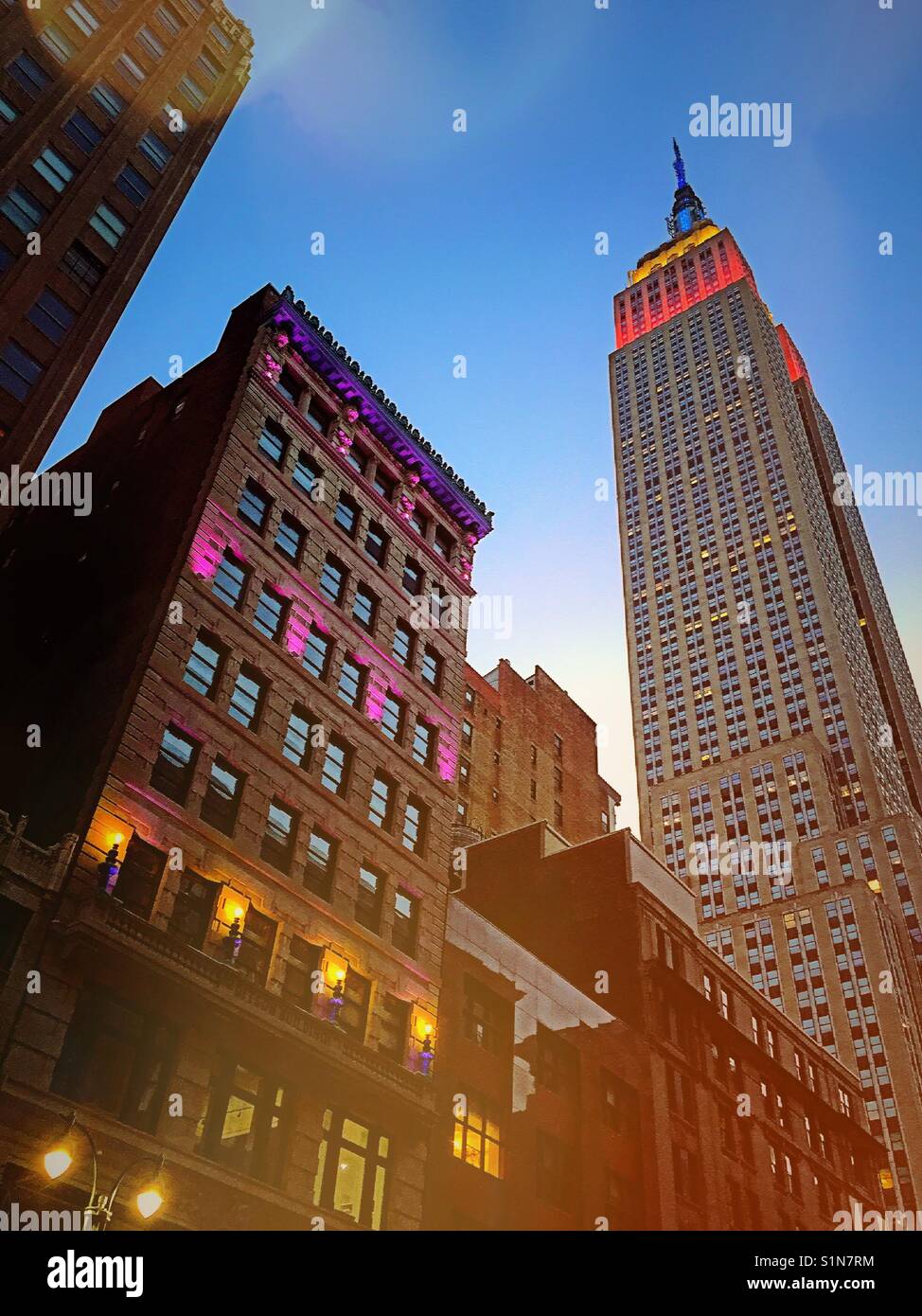 Brightly lit Ditson building an empire state building, midtown ...