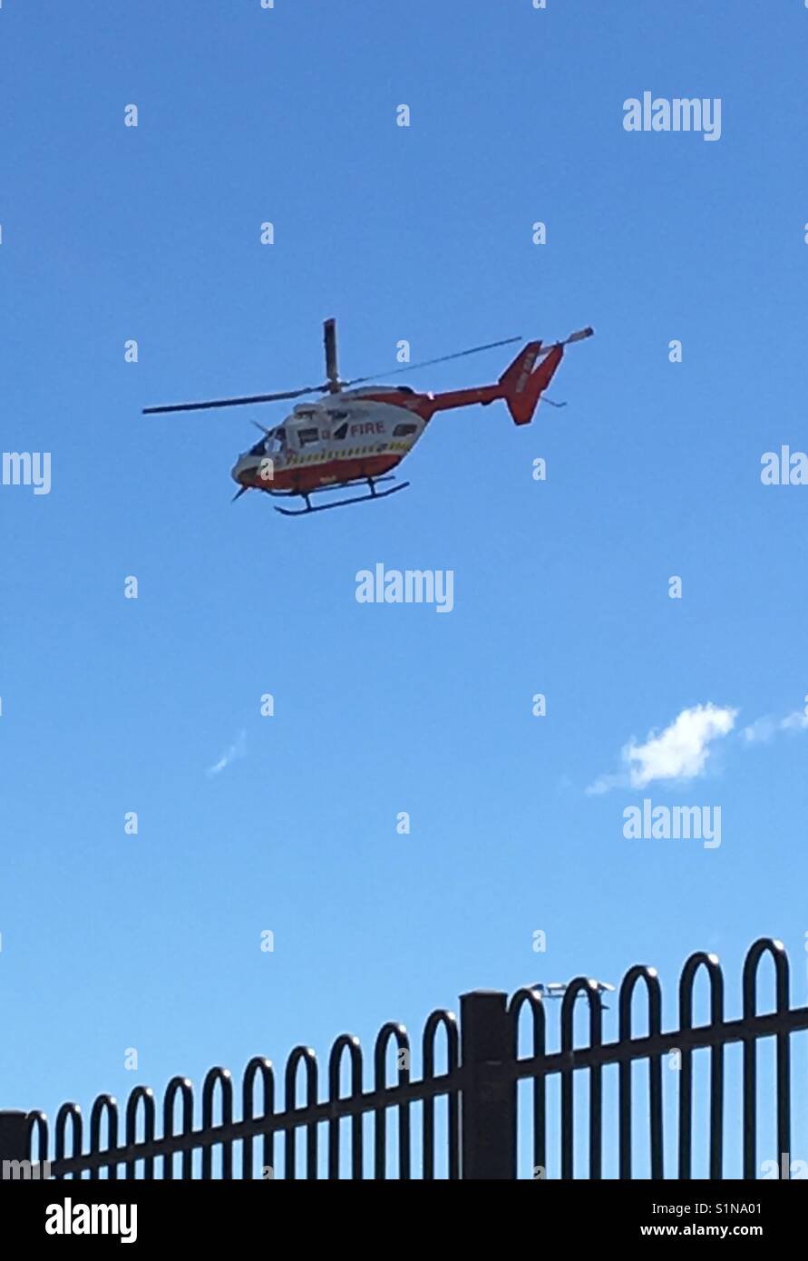 Low flying helicopter in flight against a blue sky Stock Photo - Alamy