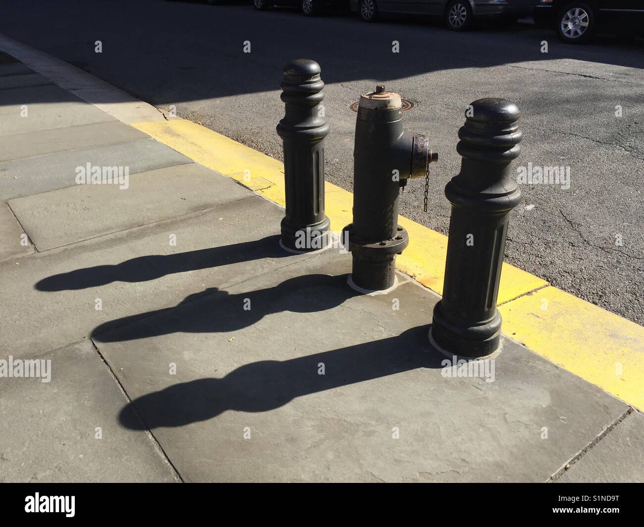 A fire hydrant next to two barriers on a sidewalk in New York City ...