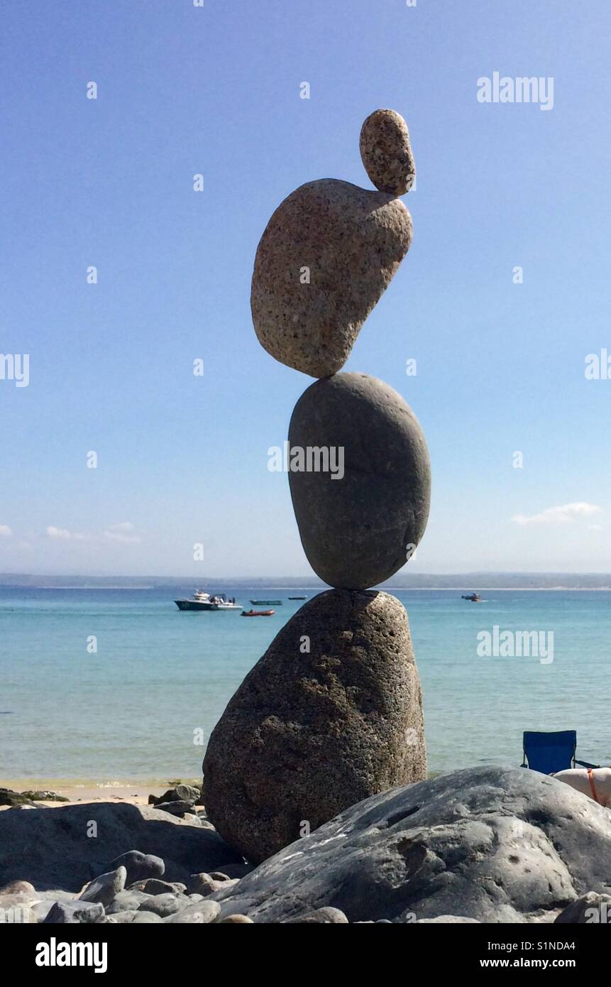 Rock balancing on the beach with sea and blue sky Stock Photo - Alamy