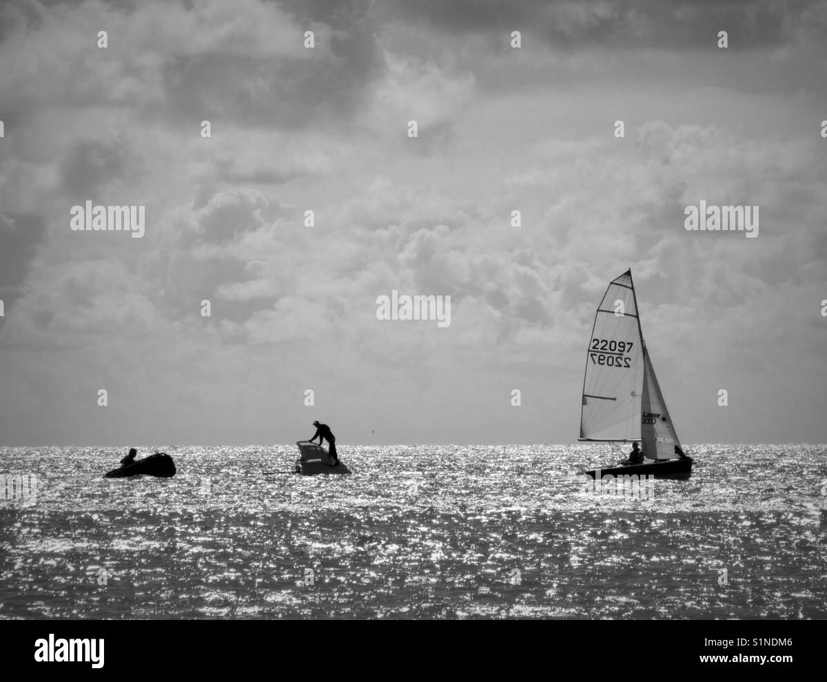 Capsized yacht, rescue boat and upright yacht at sea Stock Photo - Alamy