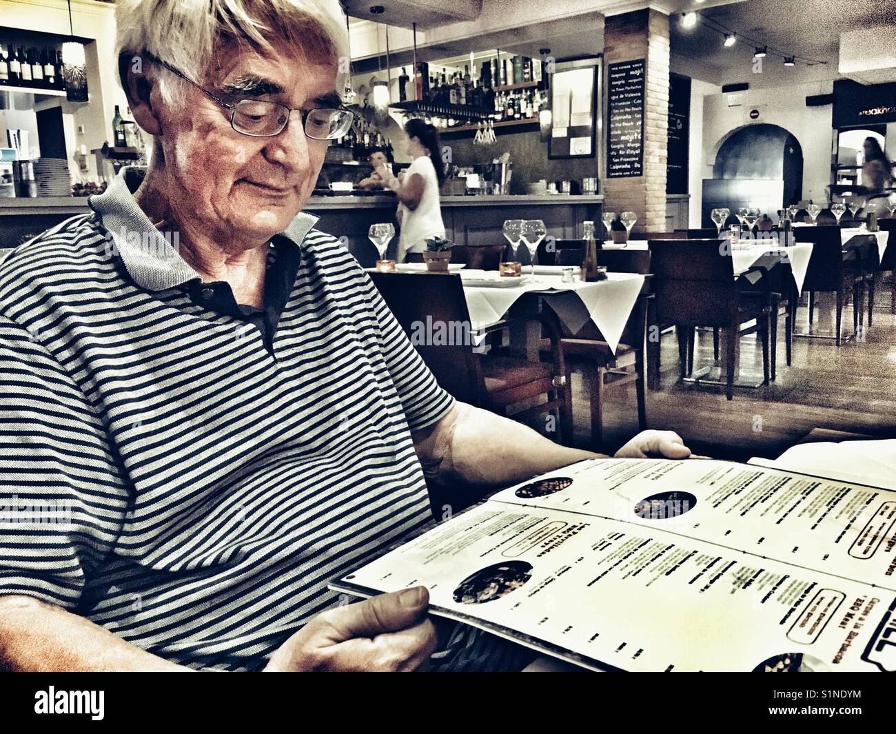 Senior man reading the menu in a restaurant, Spain Stock Photo - Alamy