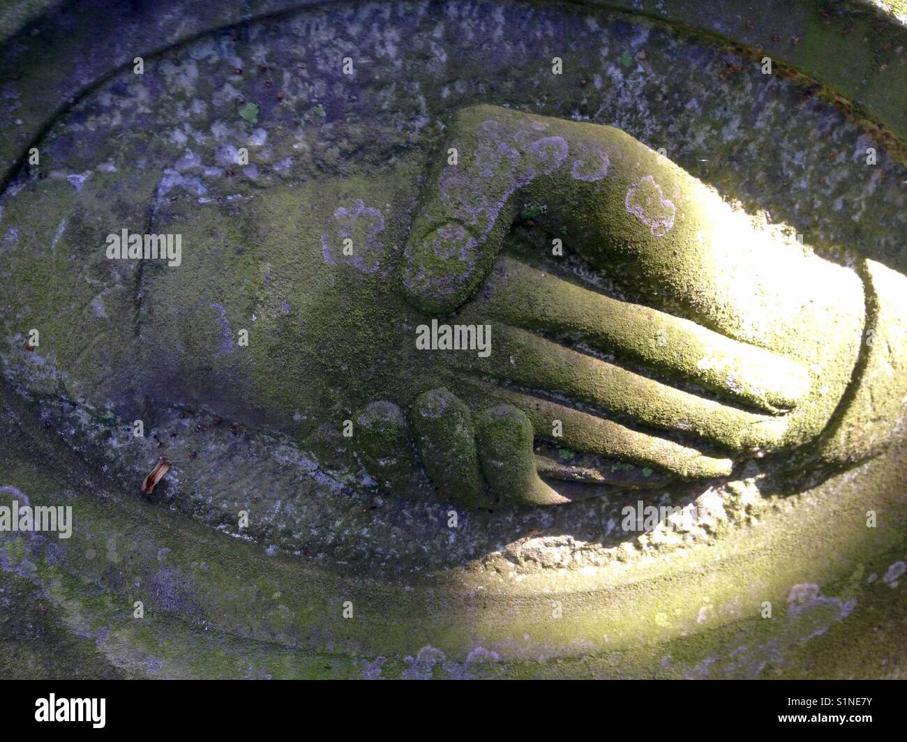 Weathered stone handshake on gravestone Stock Photo - Alamy