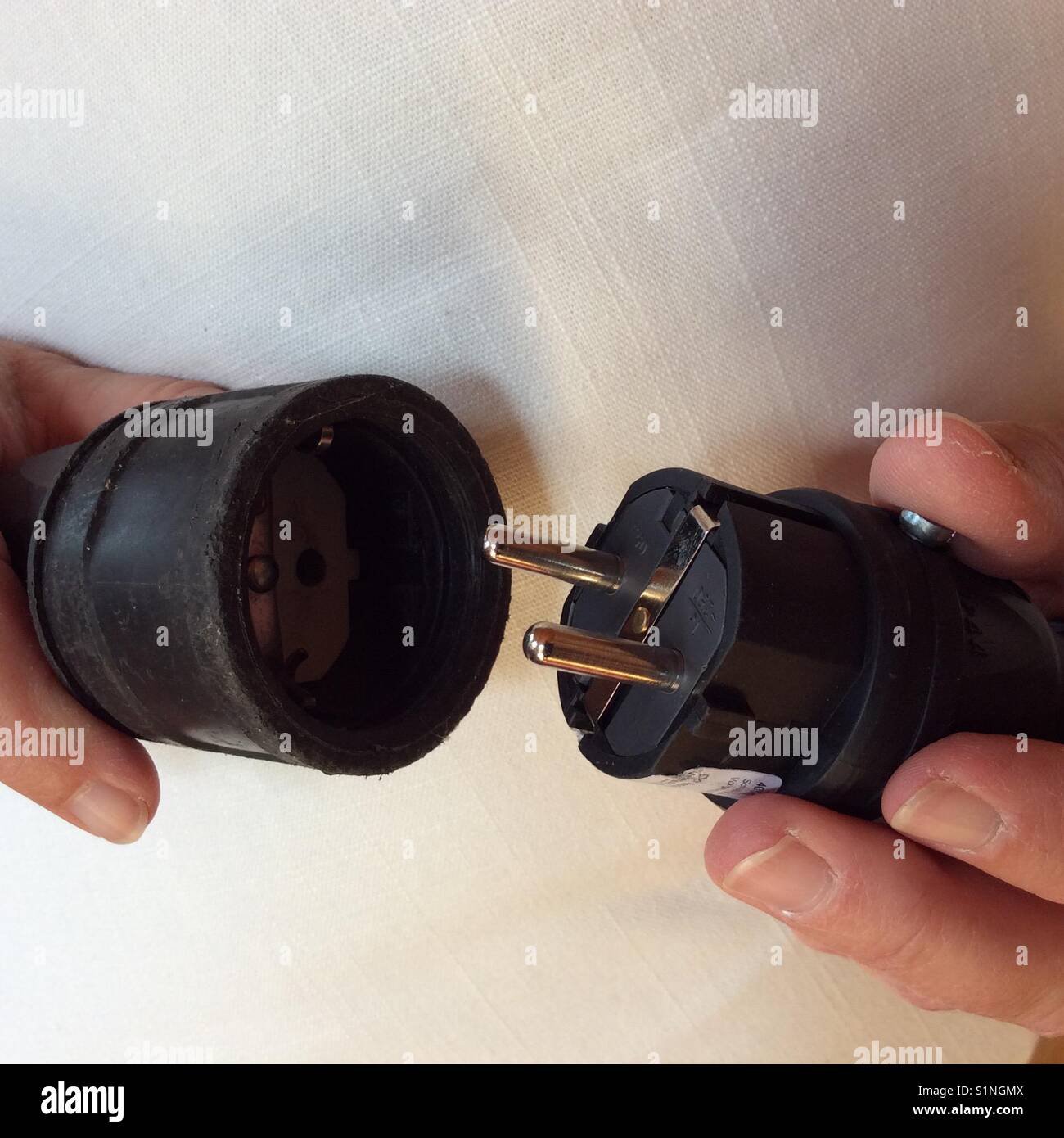 Hand holding black electrical plug hi-res stock photography and images ...