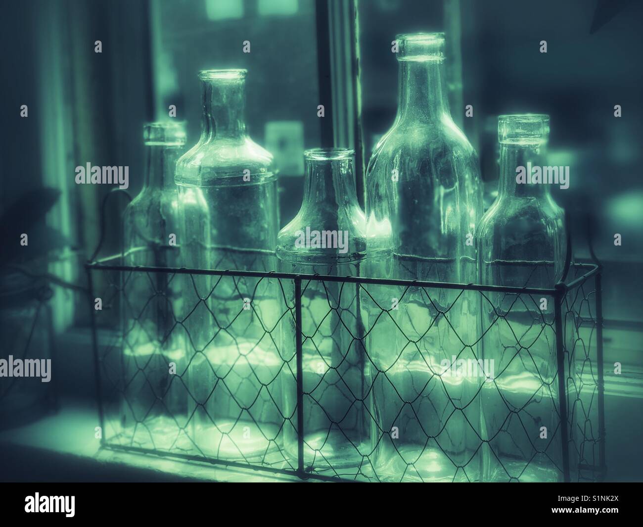 Glass bottles on display in window Stock Photo - Alamy