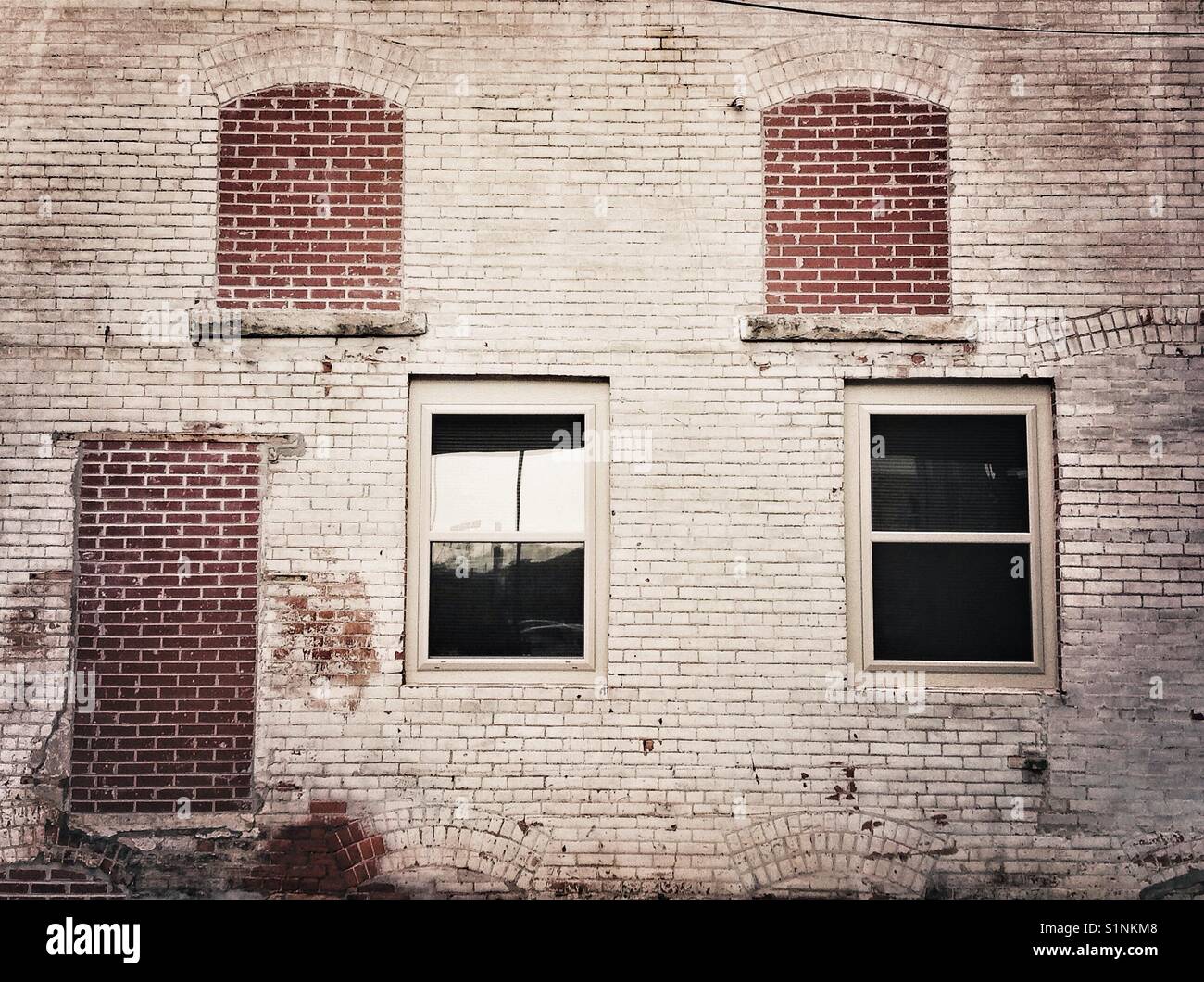 White brick wall with two windows and bricked up windows and door Stock ...