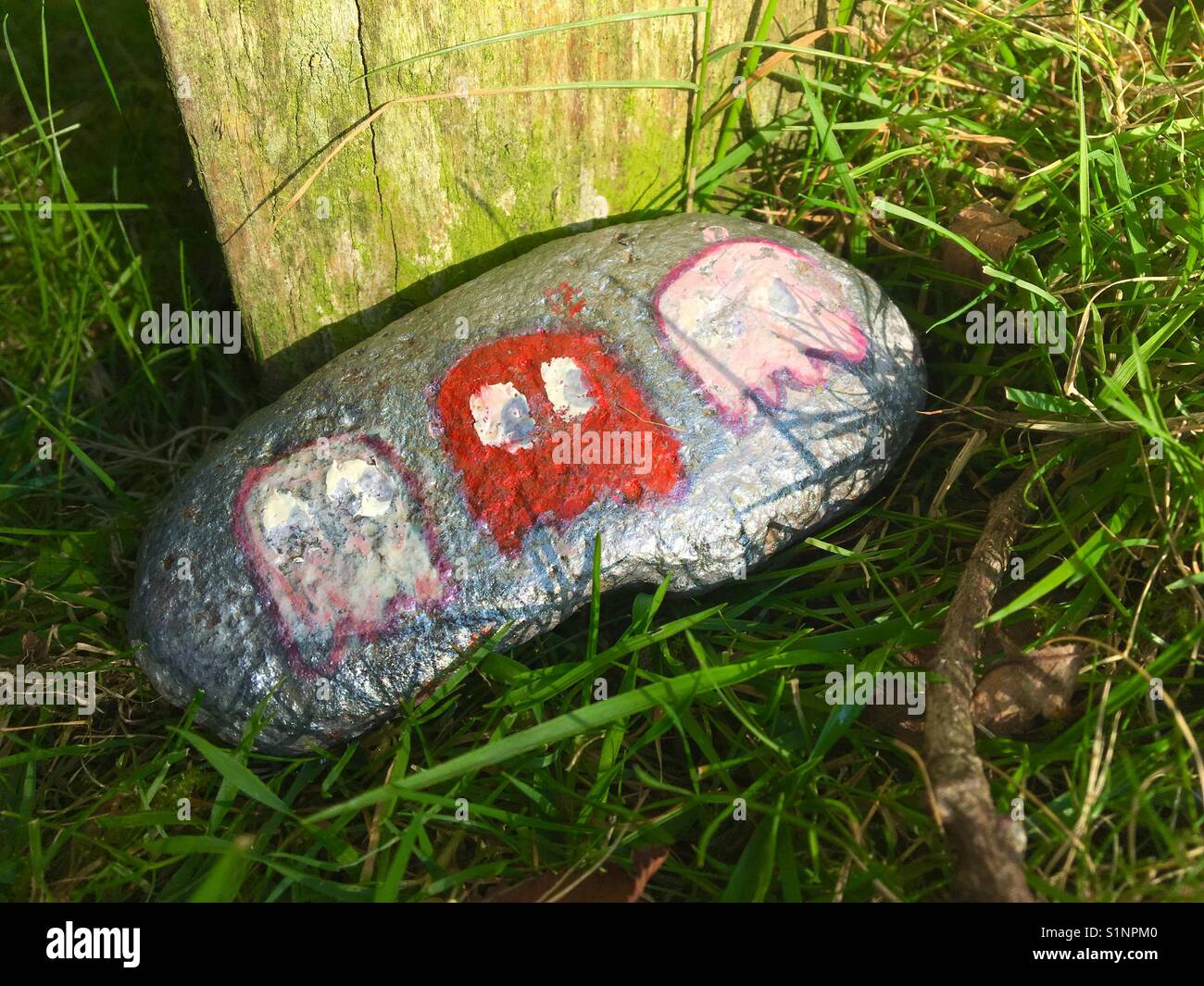 Pacman stone by wooden post Stock Photo - Alamy