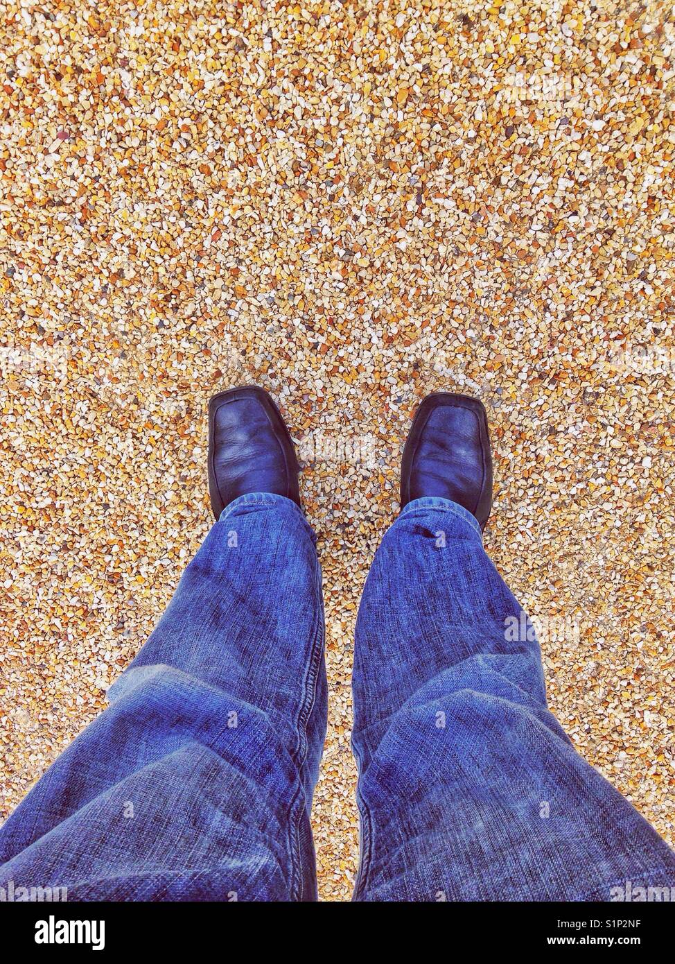 Looking down a feet on a gravel path Stock Photo - Alamy