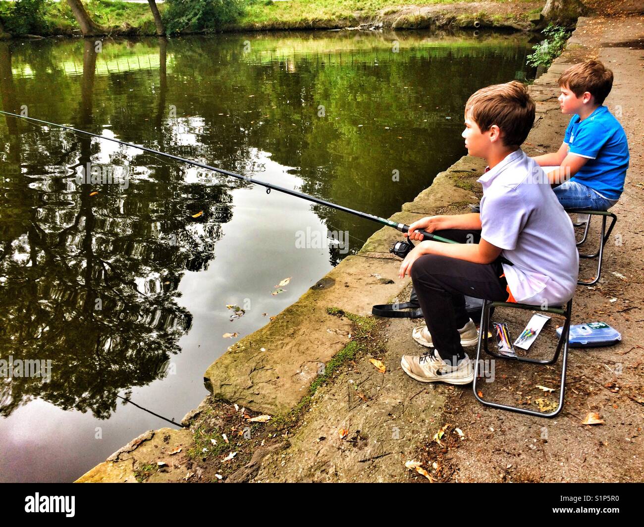 Two boys fishing in lake Stock Photo - Alamy