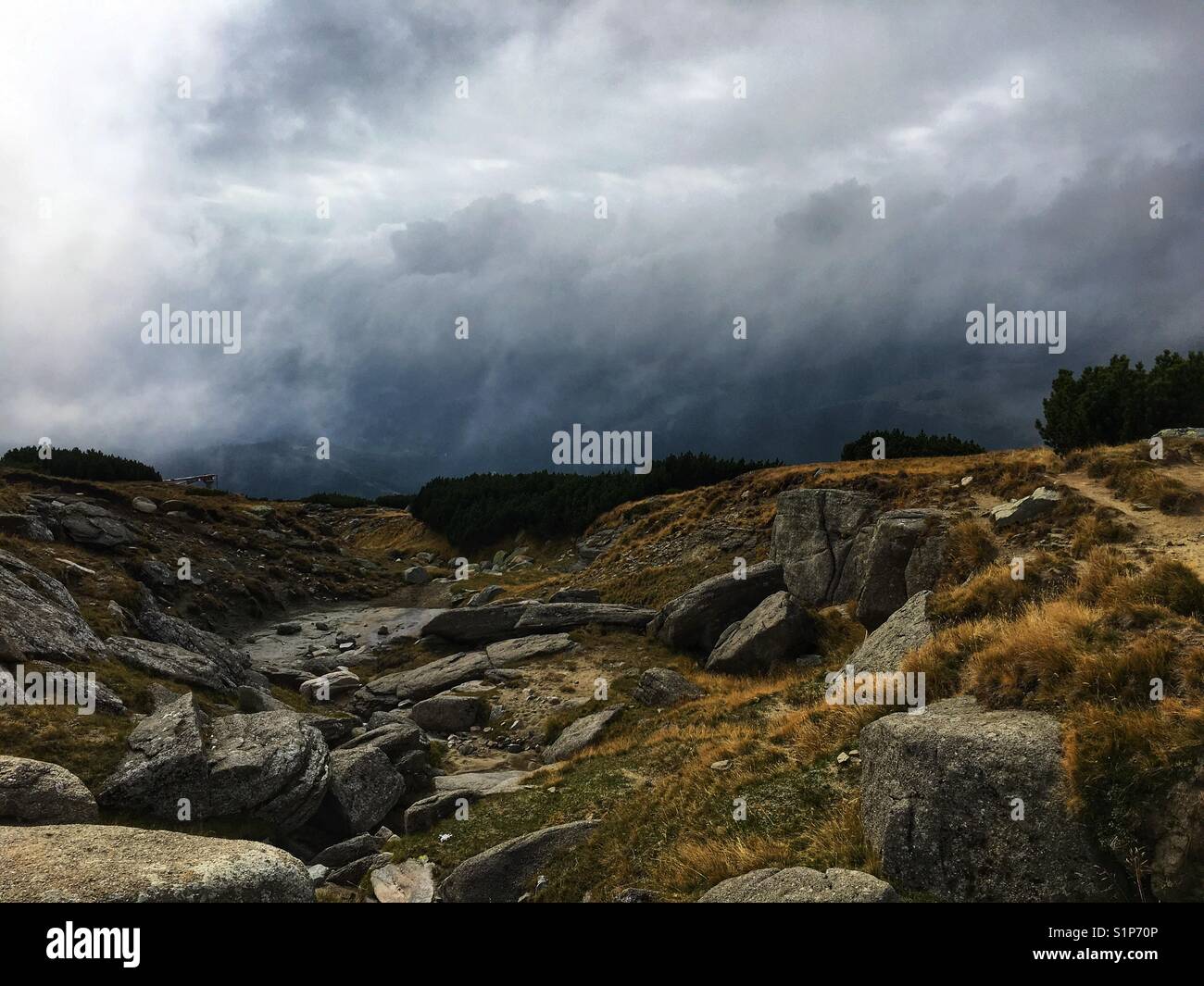 Rock descent from Romanian sphinx with storm on horizon, Bucegi ...