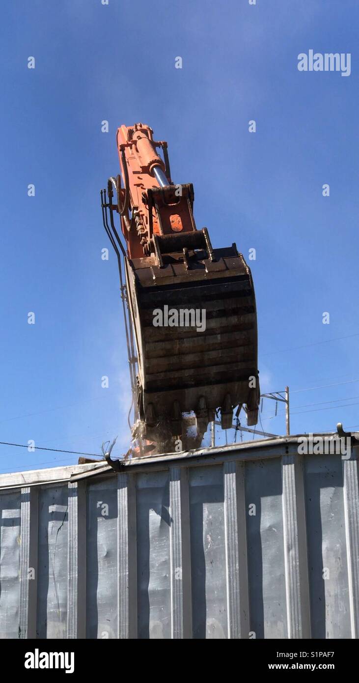 Crane unloading garbage into a dumpster Stock Photo - Alamy