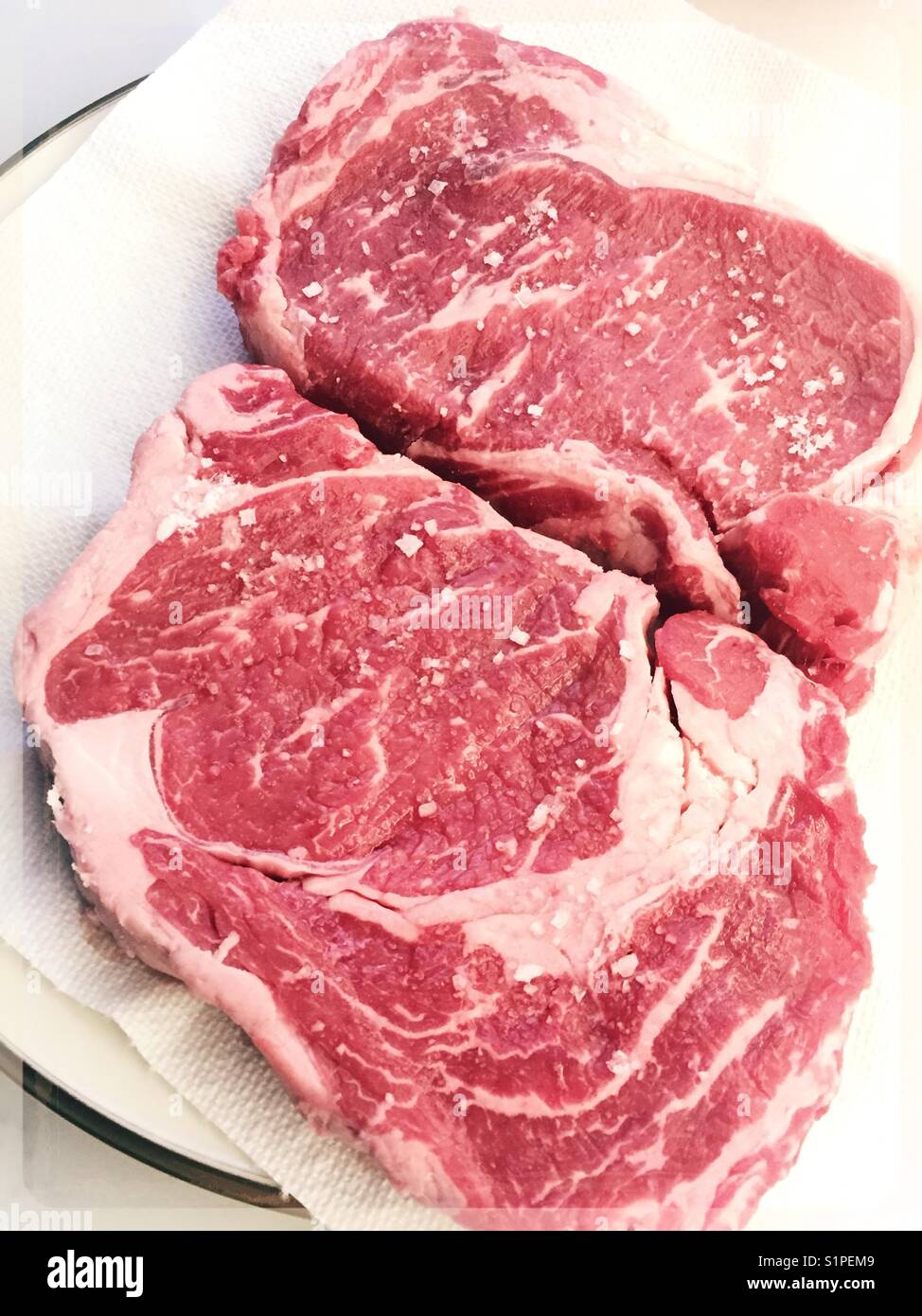 Two raw ribeye steaks salted nicely marbled USA Stock Photo - Alamy