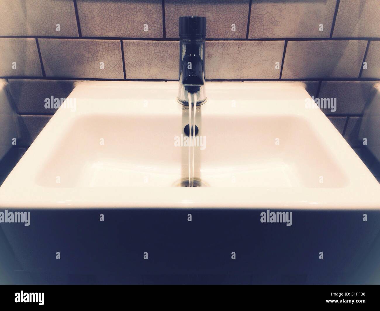 Sink and running tap in a public bathroom Stock Photo - Alamy