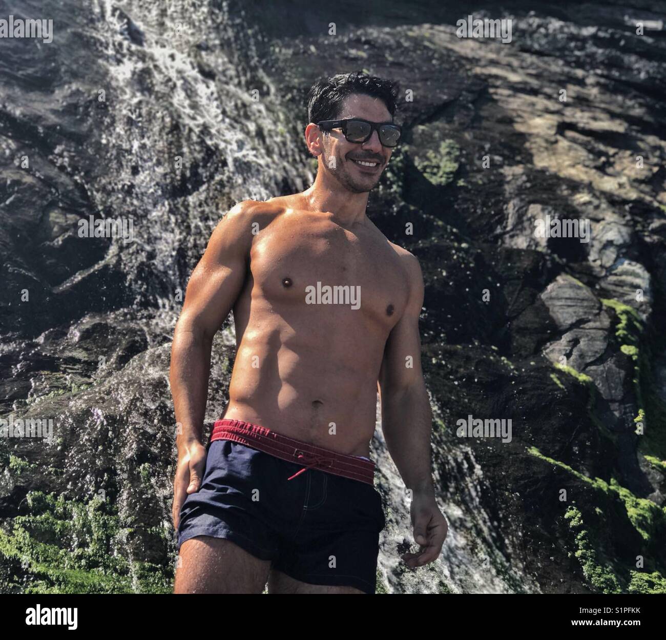 Athletic young man with rock background Stock Photo - Alamy