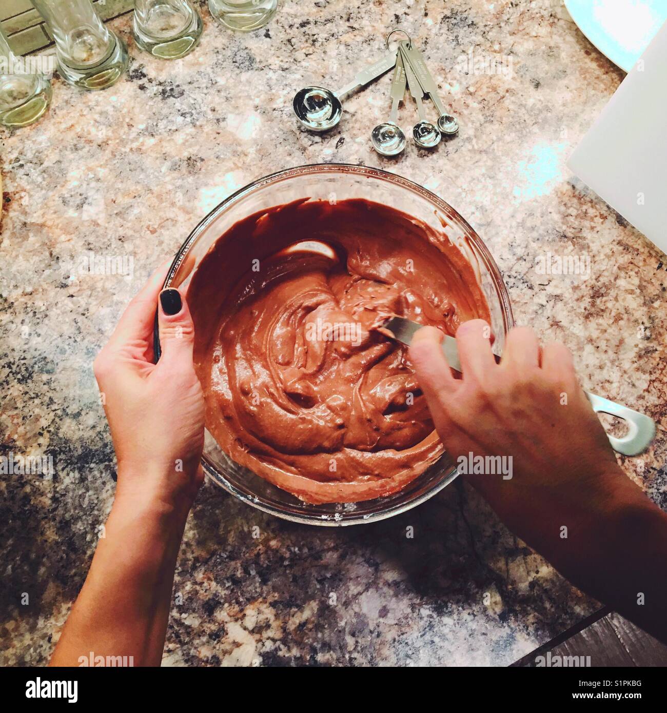 Woman's hands stirring whipped cream into melted chocolate preparing ...