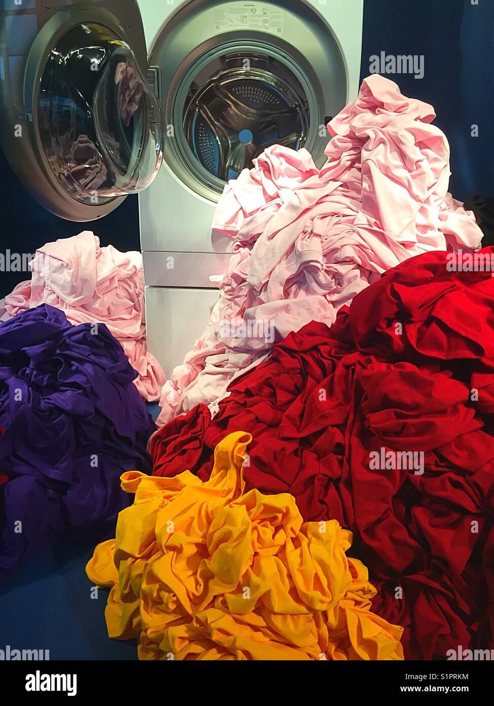 Stacks of laundry in front of an open washing machine, USA Stock Photo ...
