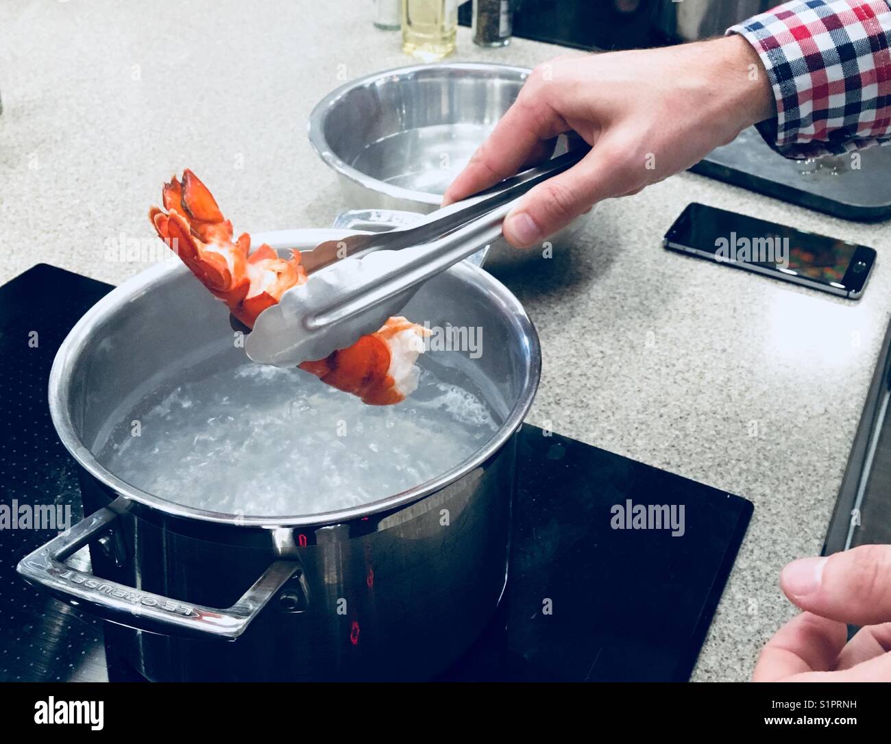a man cooking lobster in a kitchen Stock Photo - Alamy