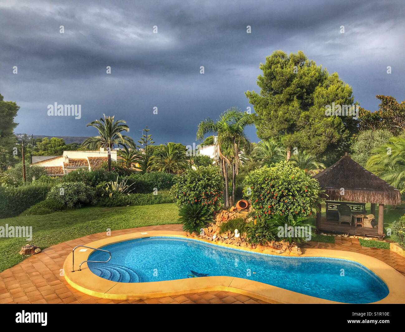 Bright sunshine on a Spanish garden after a dramatic rain storm Stock ...