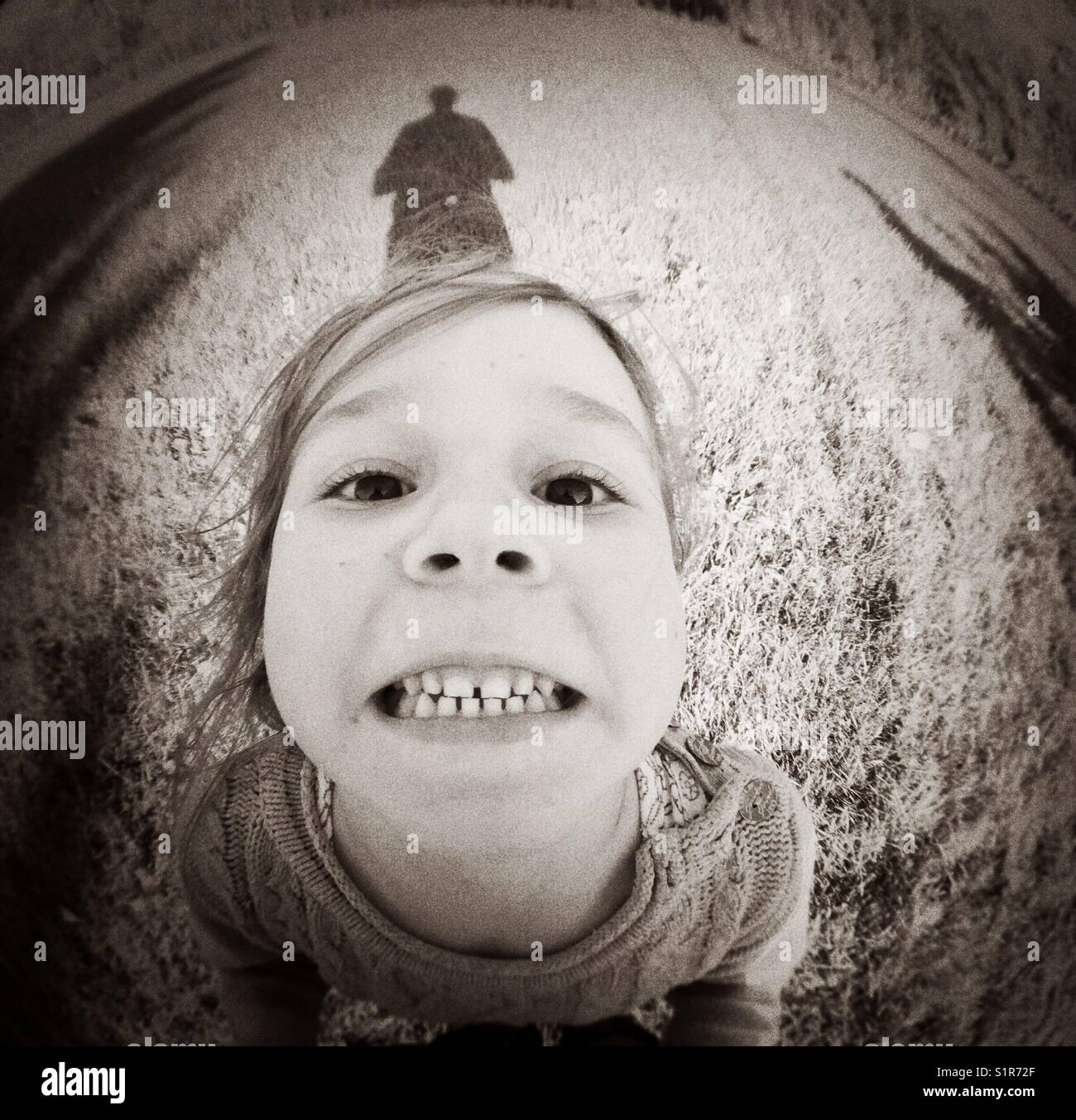 Little girl looking up at parent taking picture Stock Photo - Alamy