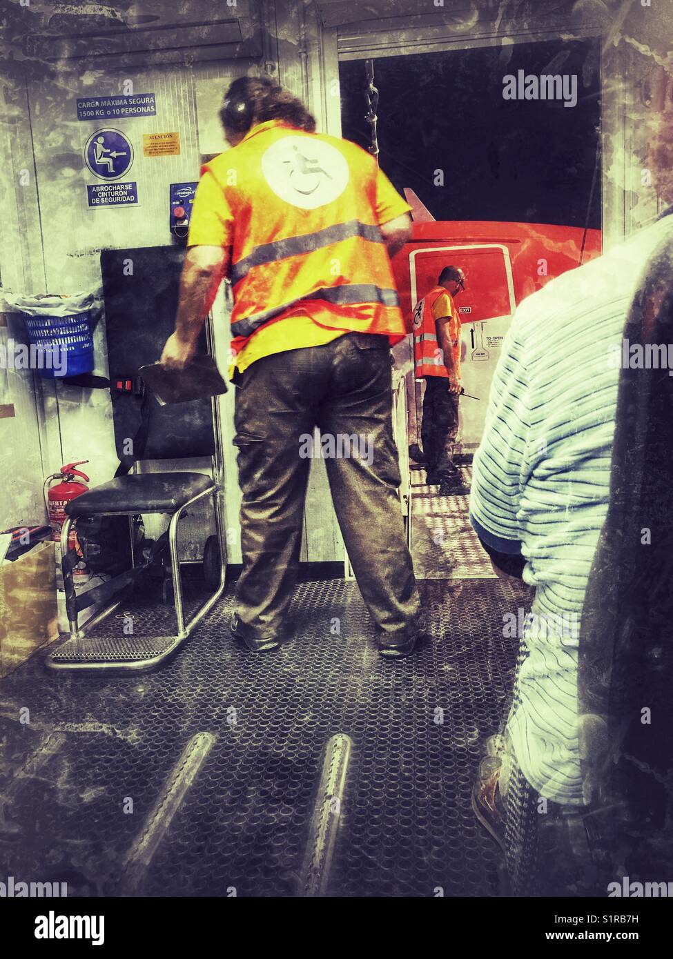 airport ground crew helping disabled passengers to board an EasyJet ...