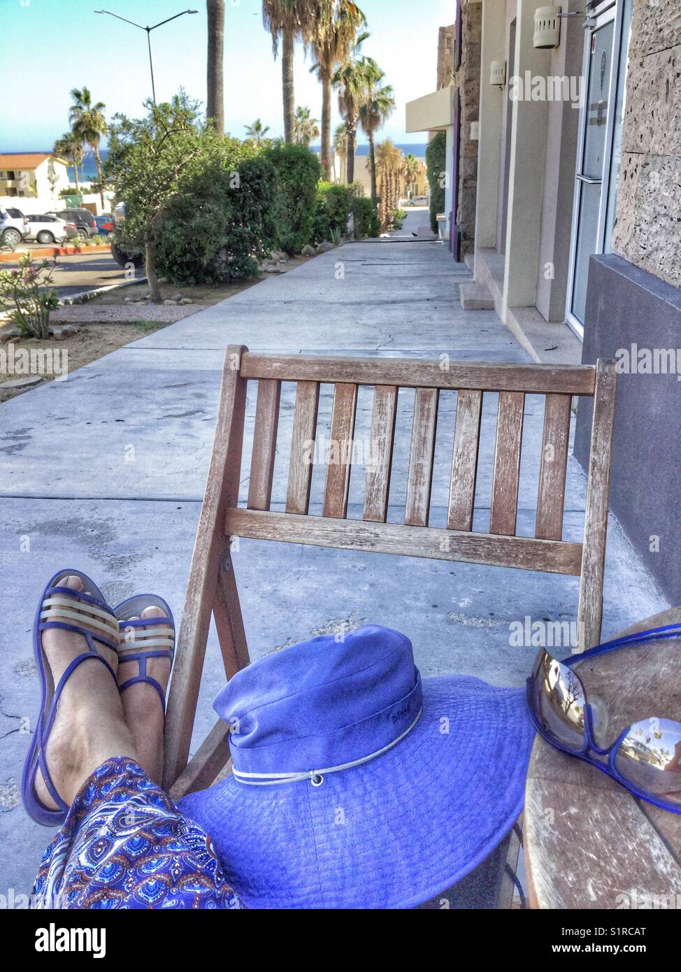 Woman relaxing with her feet resting on a wooden chair Stock Photo - Alamy