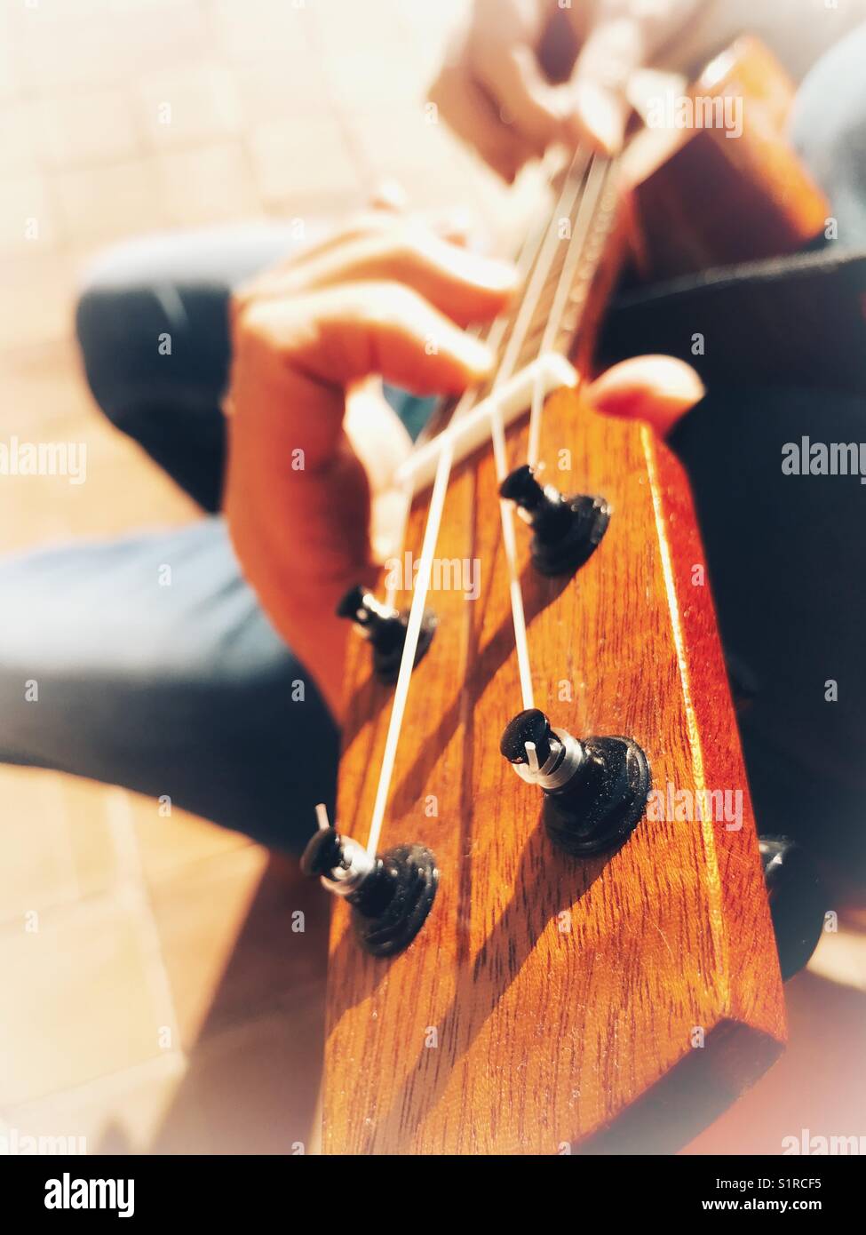 Woman playing a ukulele, high angle side view Stock Photo - Alamy