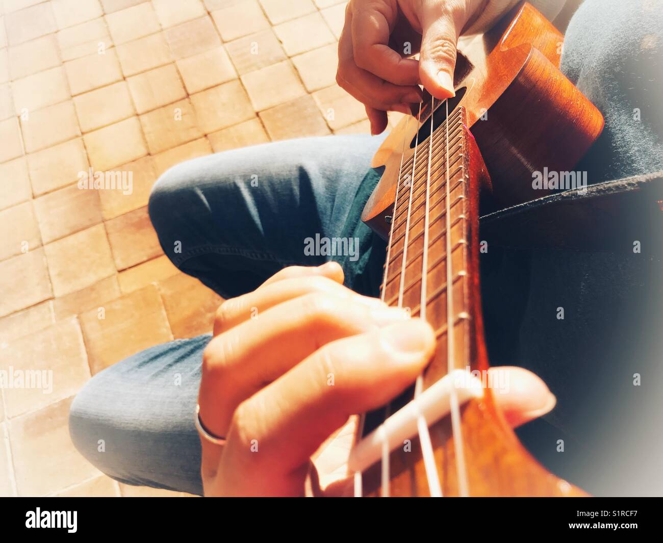 Woman playing a ukulele, high angle side view Stock Photo - Alamy
