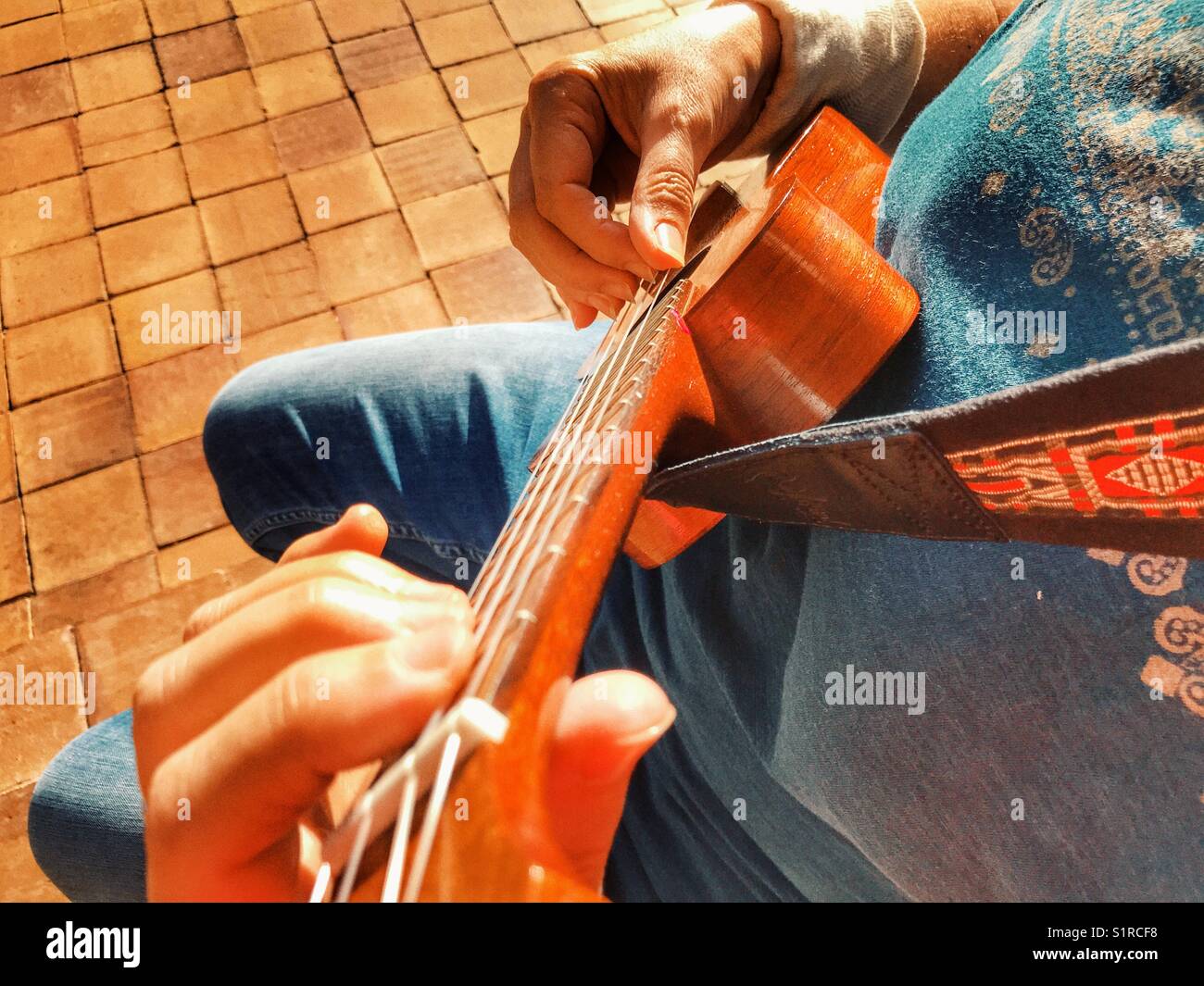 Woman playing a ukulele, high angle side view Stock Photo - Alamy
