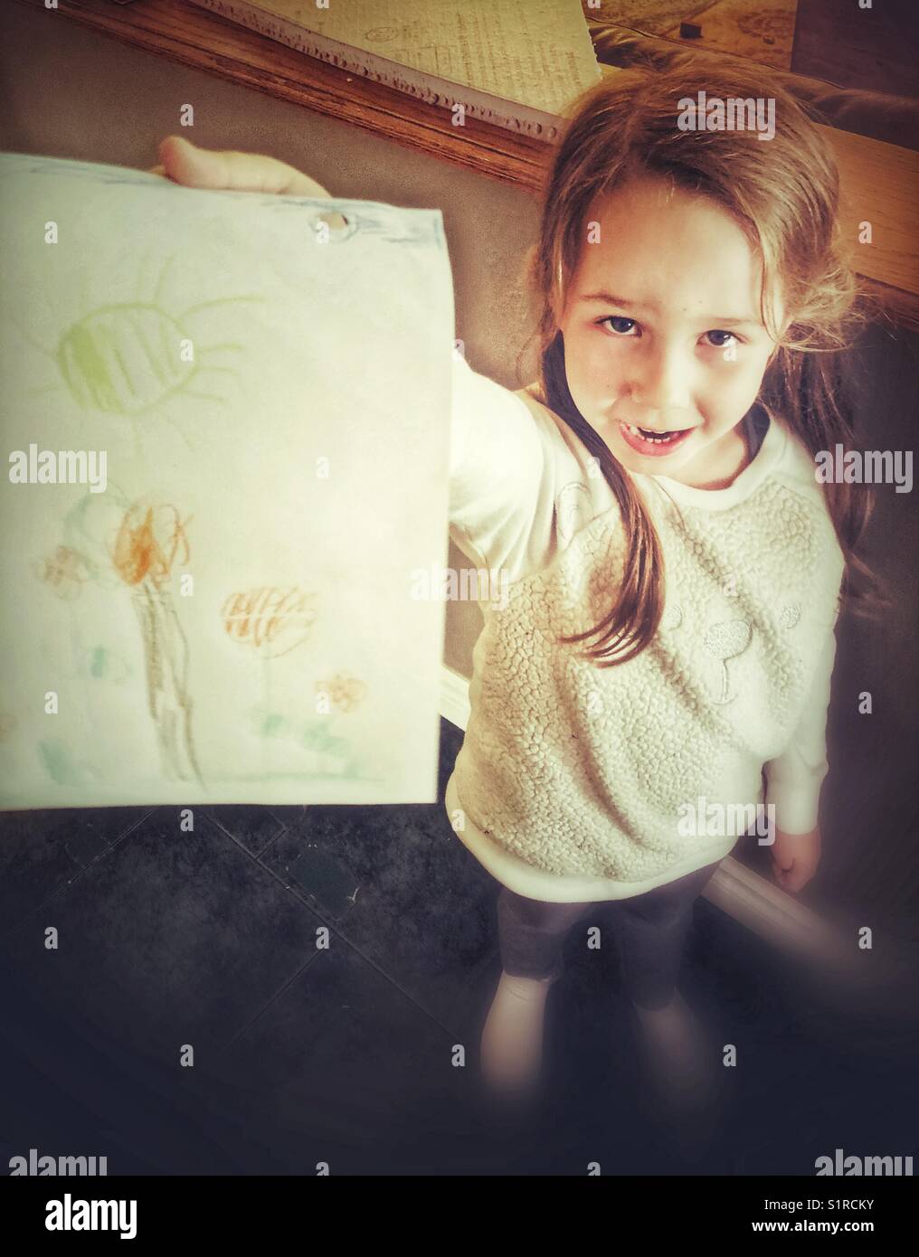 Young girl showing off crayon drawing Stock Photo - Alamy