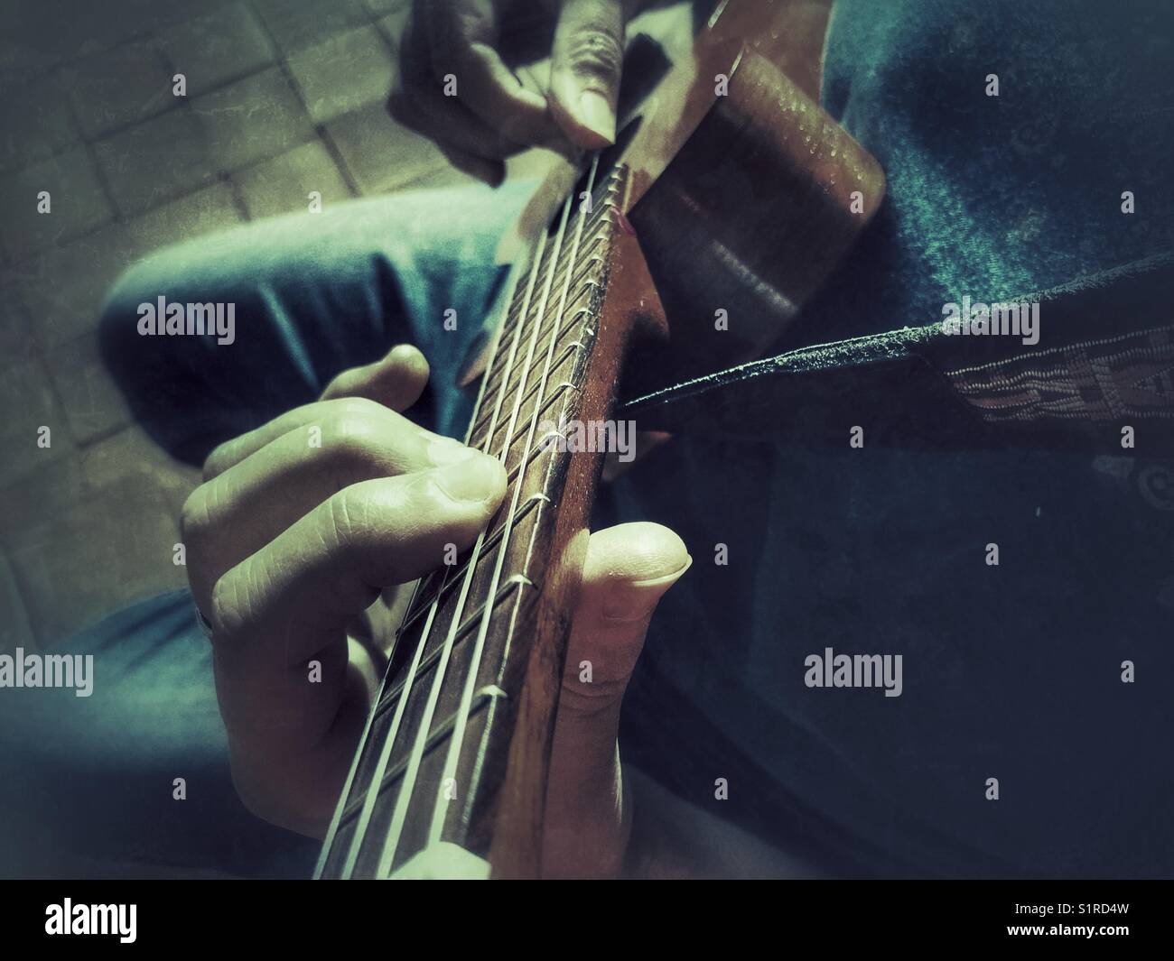 Woman playing a ukulele, high angle side view Stock Photo - Alamy