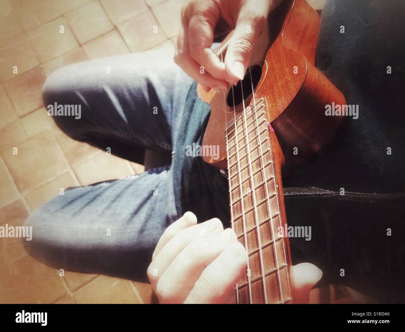 Woman playing a ukulele, high angle side view Stock Photo - Alamy