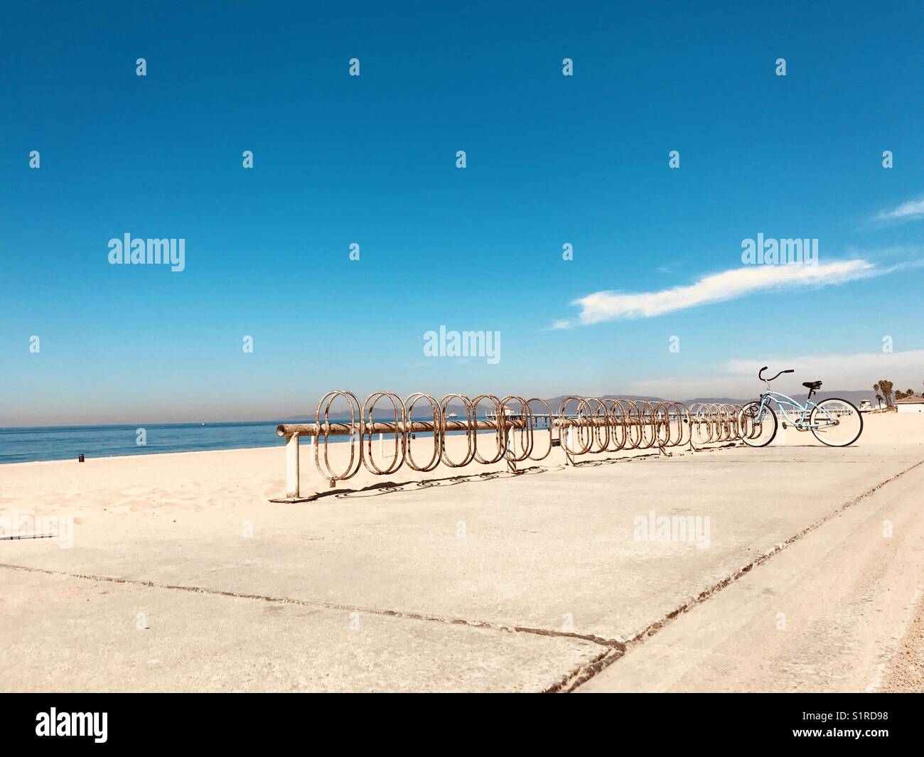 A blue bike parked in a bike rack at the beach. Manhattan Beach ...