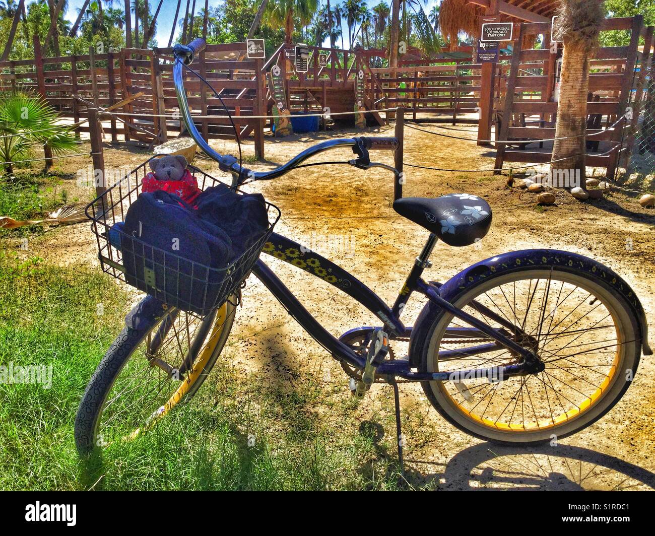 A bike with a small teddy bear parked in front of stables Stock Photo ...