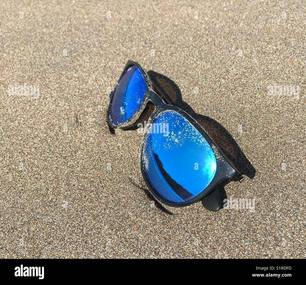 Sunglasses on sandy beach Stock Photo - Alamy