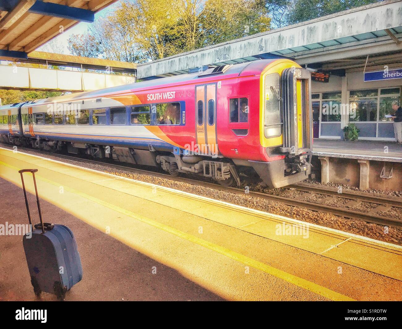 Wheelie bag left unattended on train station platform with a train on ...