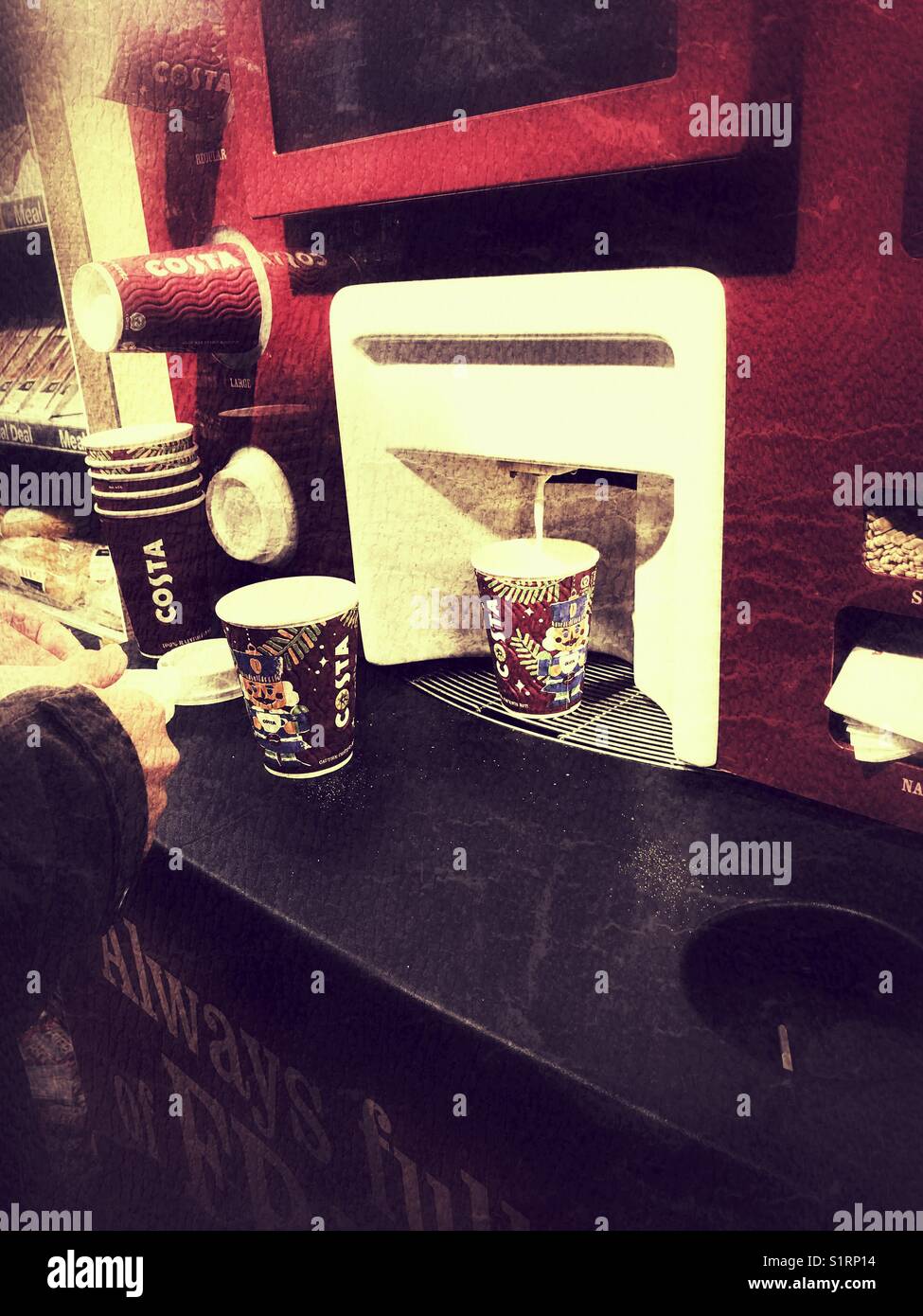 Woman using a Costa coffee self service vending machine in a ...